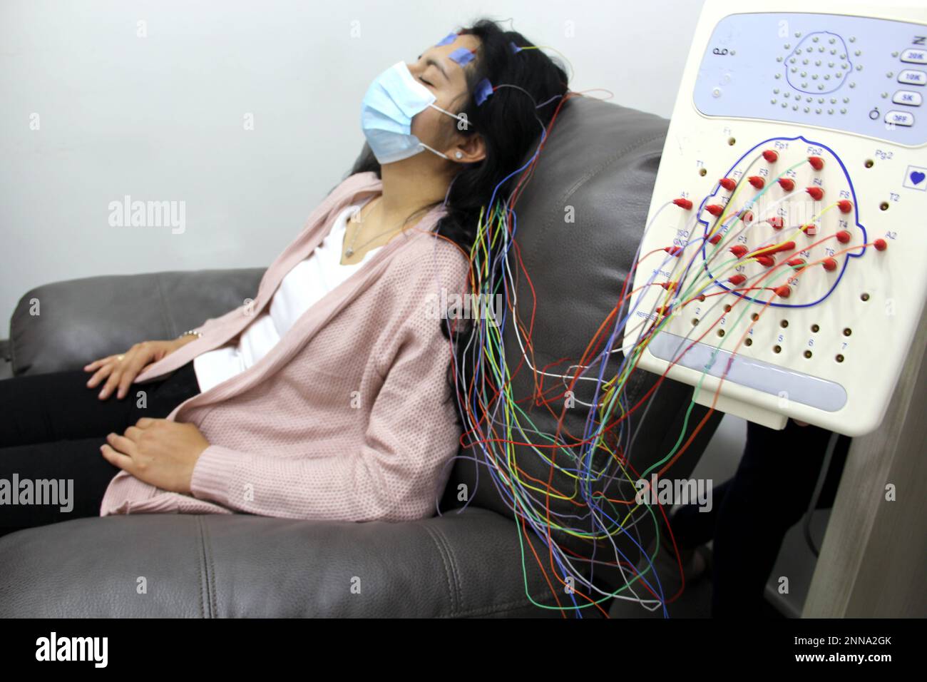 Latin woman with protection mask in medical tests, electroencephalogram ...