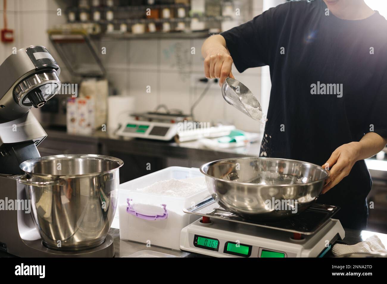 A woman cook works in a modern industrial kitchen. The process of ...