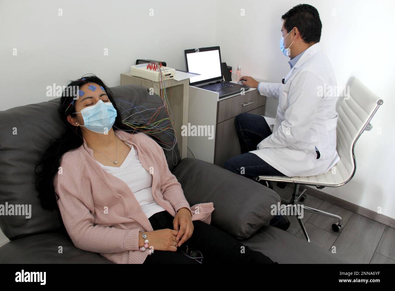 Latin woman and doctor with protection mask in medical exams performing ...