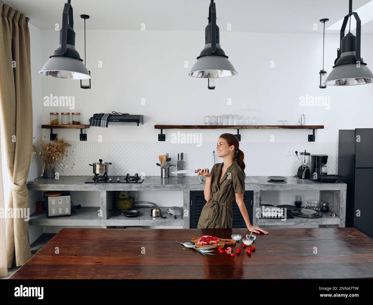 Happy woman chef standing in Stylish minimalist kitchen interior with ...