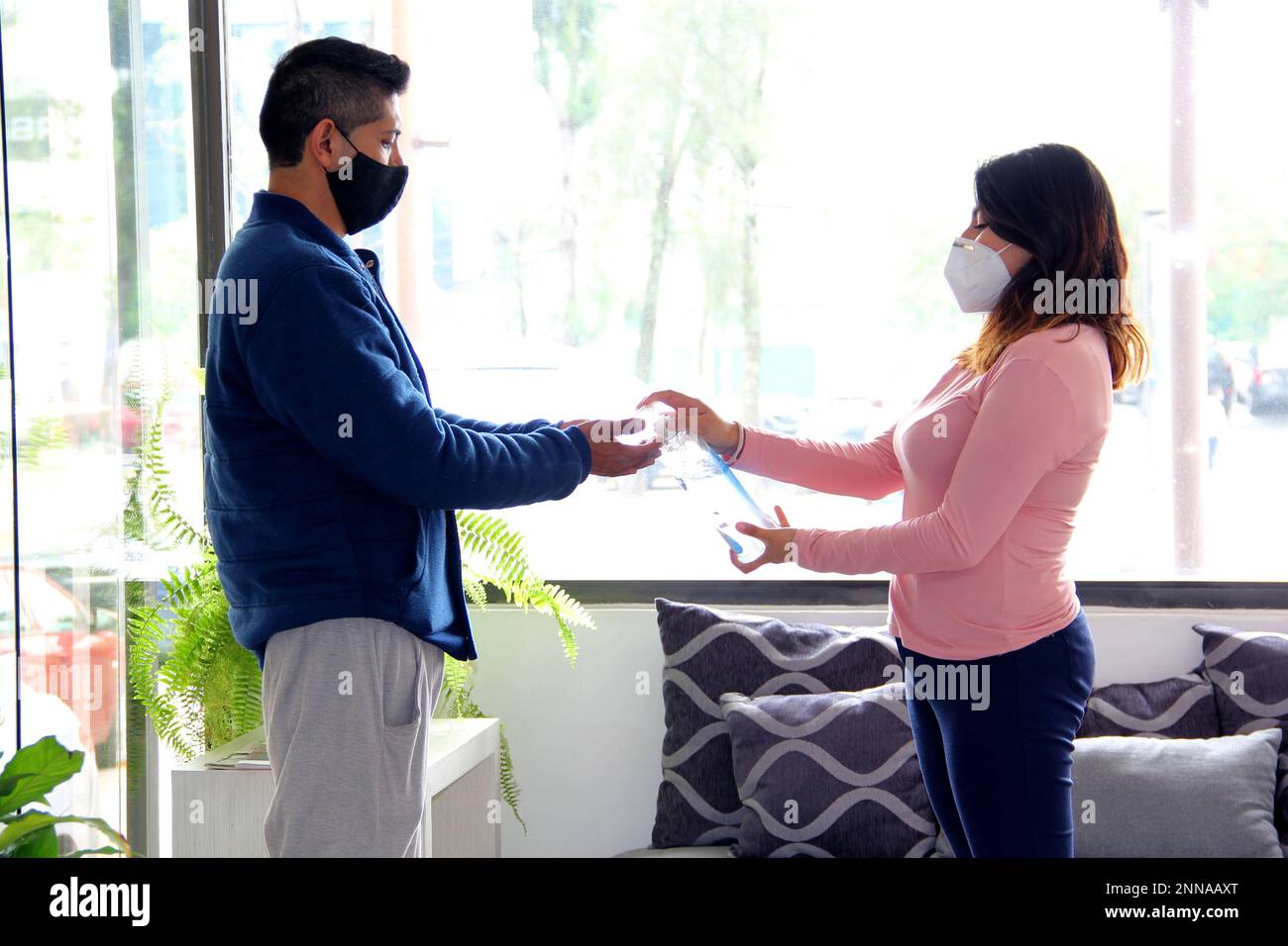 New normal, Latin woman with protection mask receives Latin man with ...