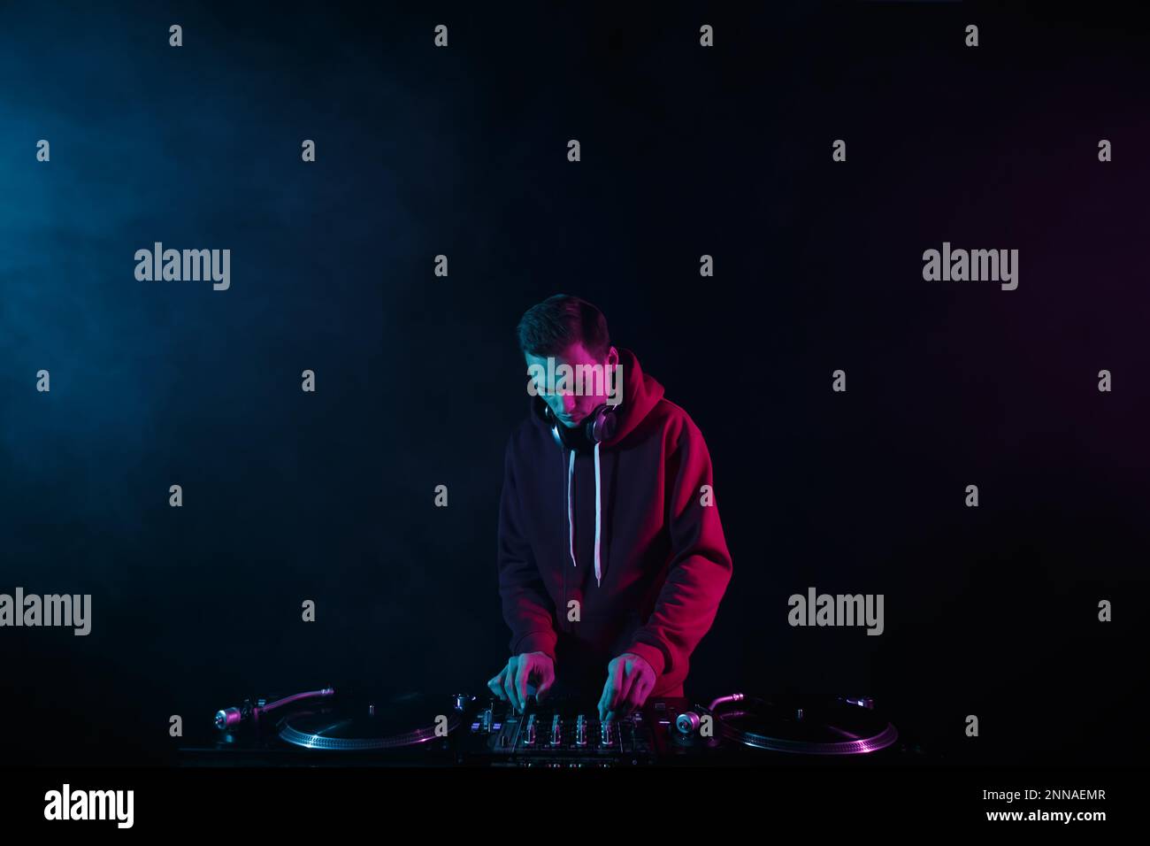 Hip hop dj plays set with vinyl records and sound mixer. Disc jockey ...