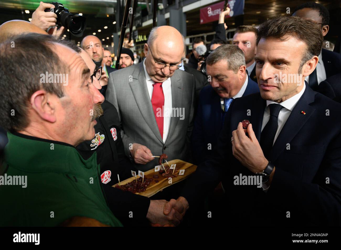 Paris, France. 25th Feb, 2023. Emmanuel Macron grabs a piece of ...