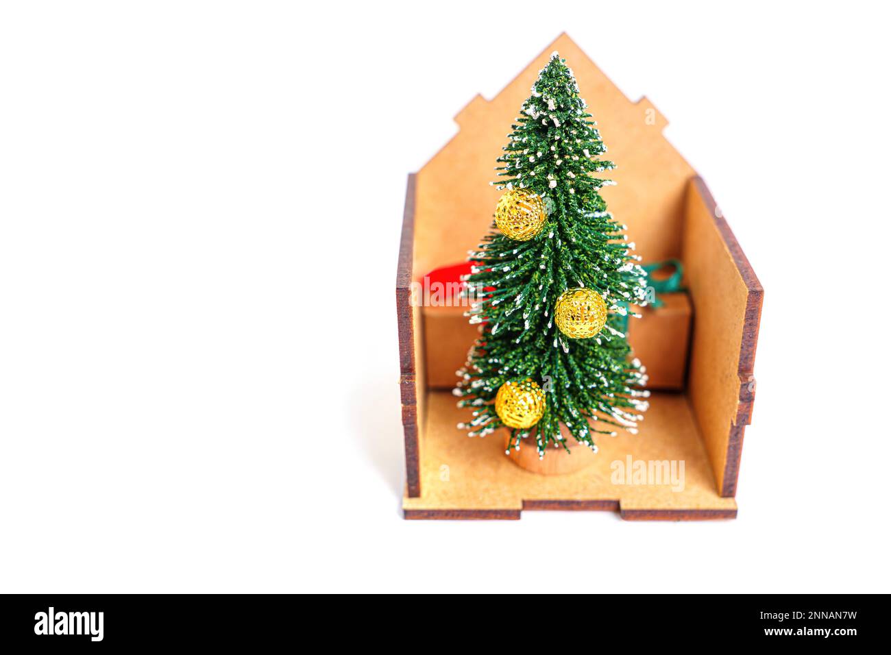 Christmas tree figurine and wrapped presents placed inside a toy wooden ...