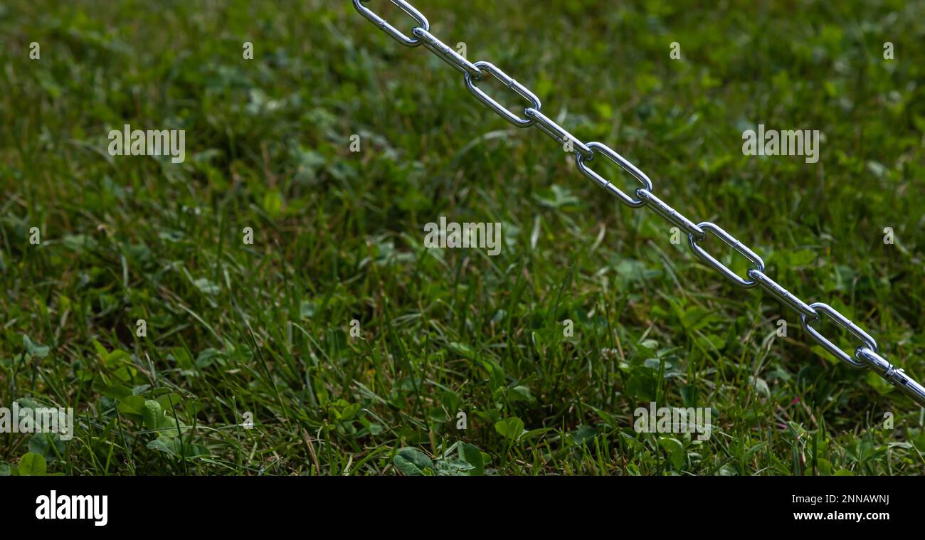 steel non-rusty chain on grass background, frame Stock Photo - Alamy