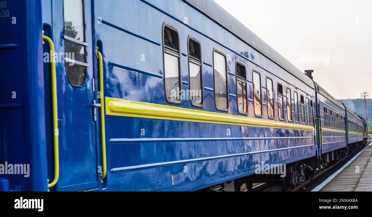 a blue passenger train travels along the track Stock Photo - Alamy