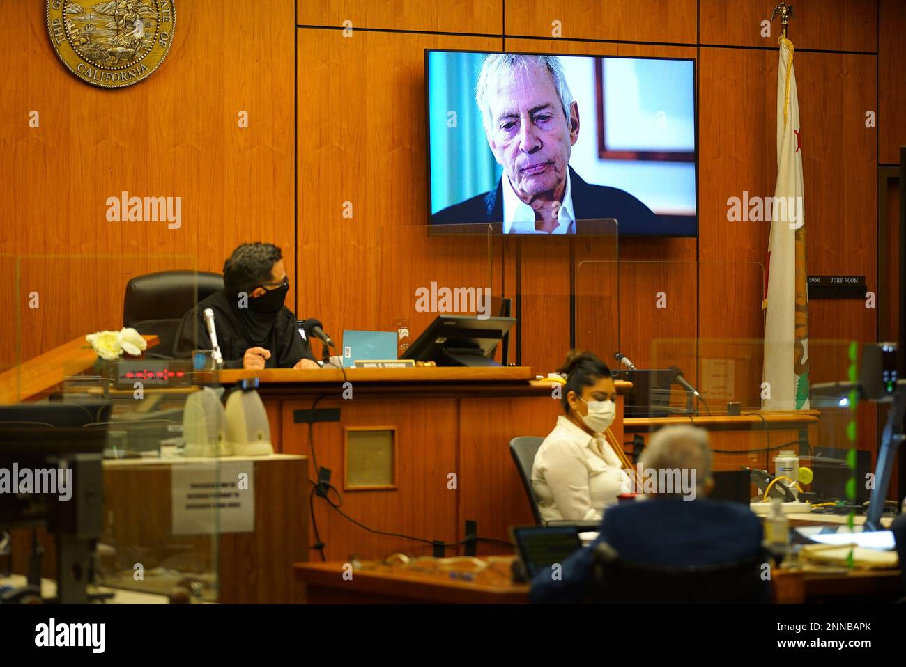 A TV still frame of Robert Durst appears on a screen in the courtroom ...