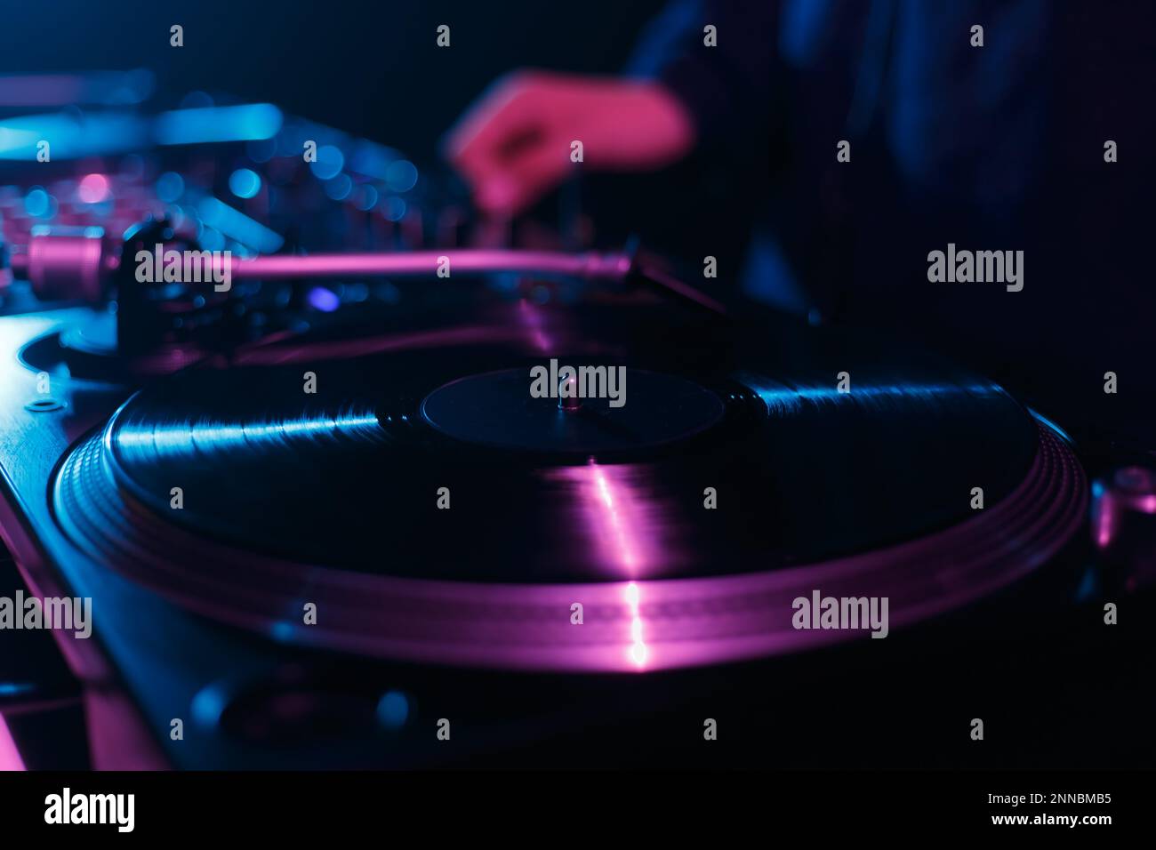 DJ turntable player playing vinyl record on techno party in dark night ...
