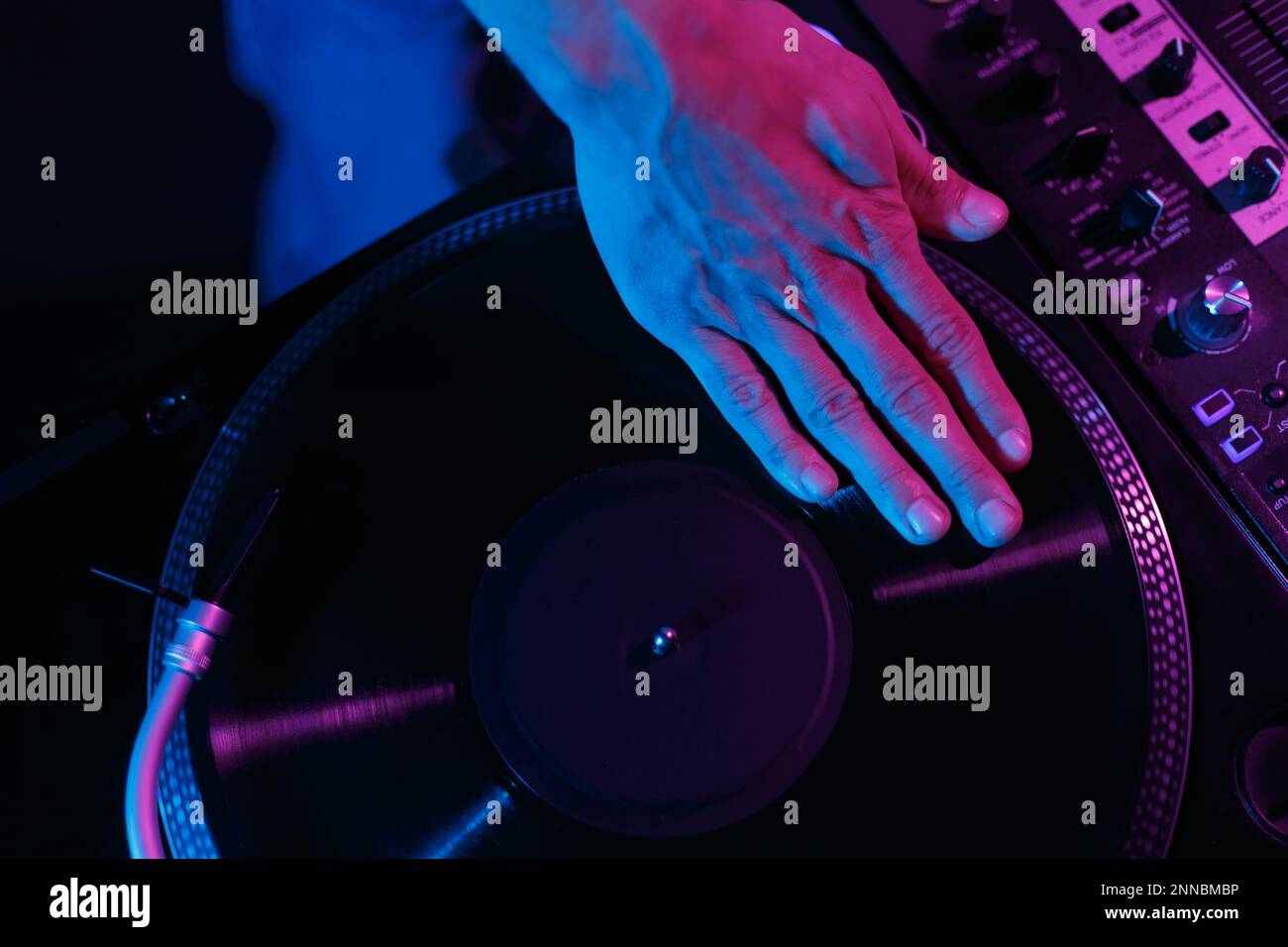 Hip hop dj scratching vinyl record on party in night club. Overhead ...