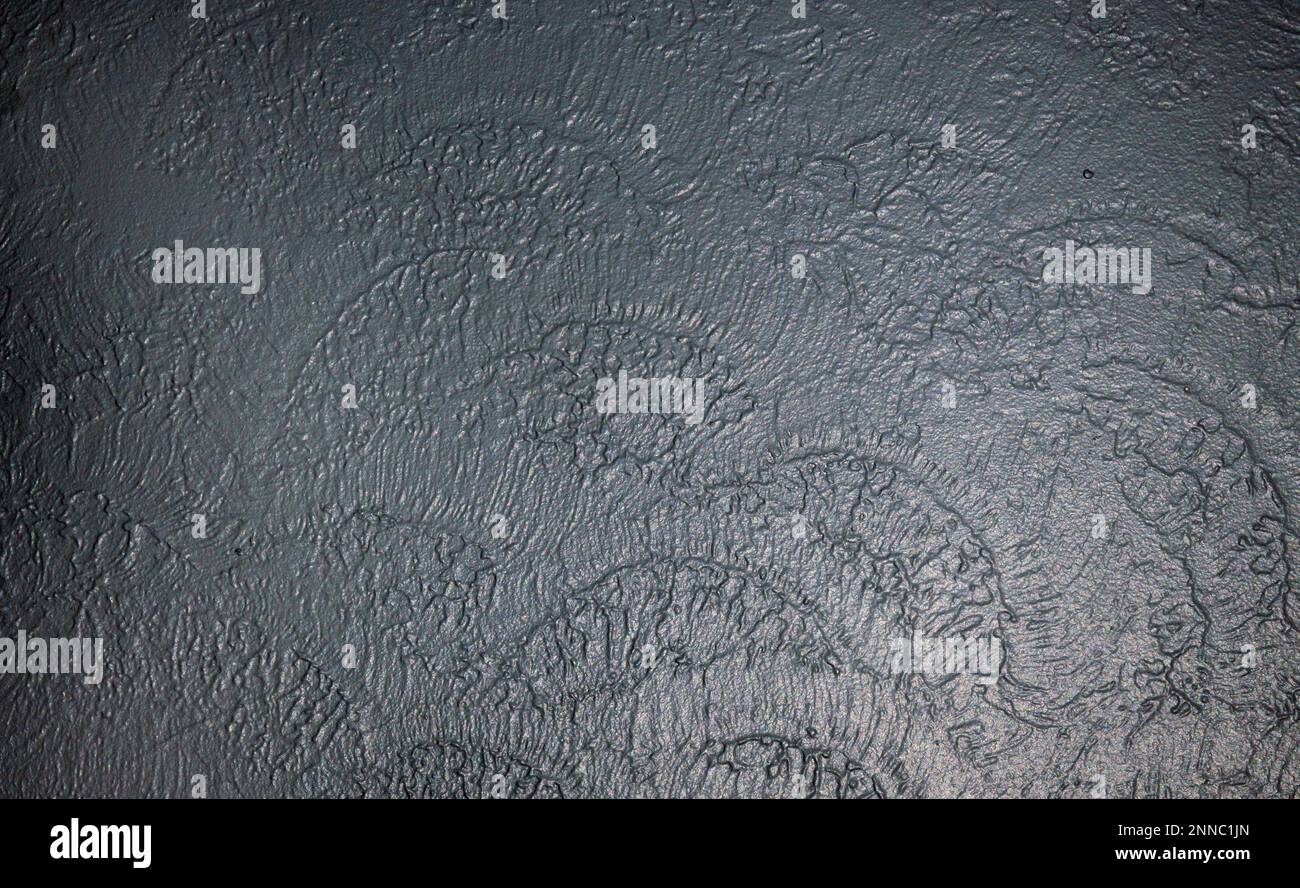 A freshly painted grey wall on a textured plaster surface. Nice detail ...