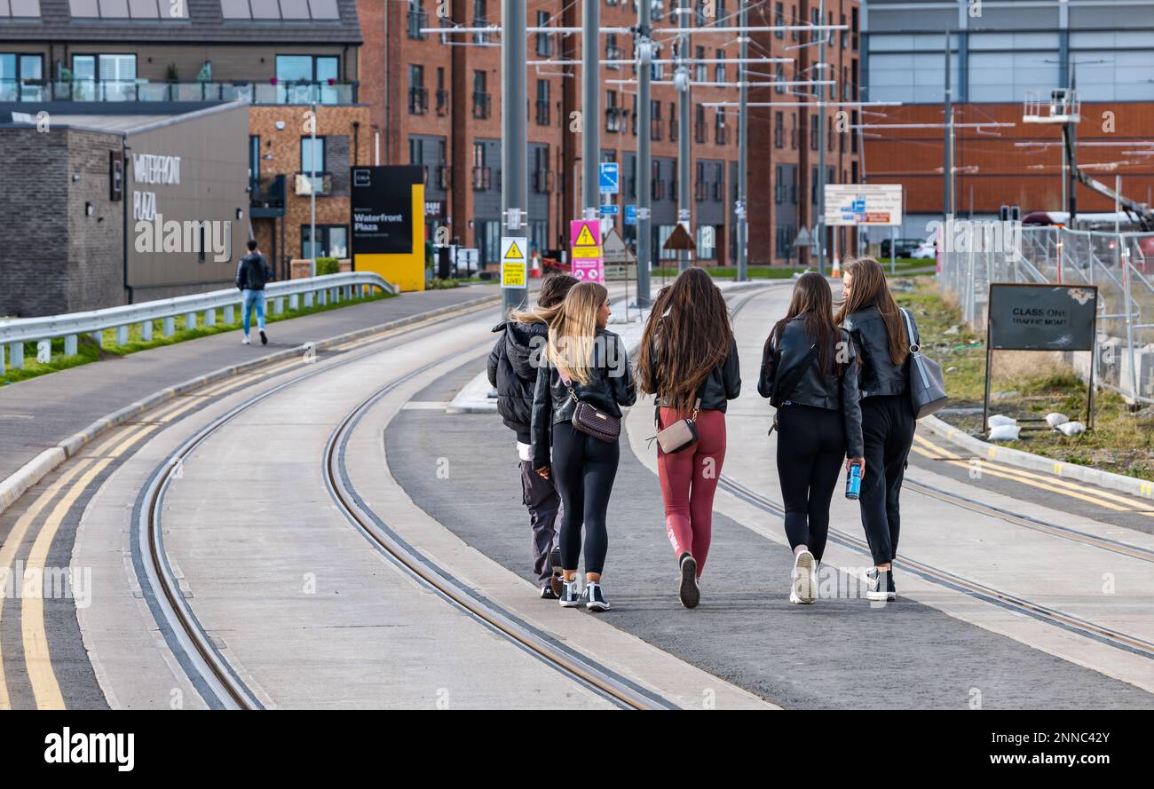 Group of teenage girls walking along tram lines on Ocean Drive, Leith ...