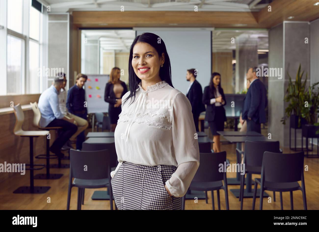 Portrait of attractive smiling brunette business coach trainer woman in ...