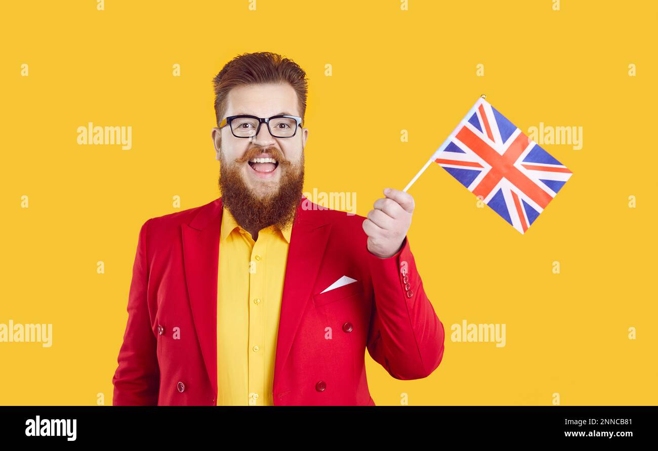 Happy smiling British guy isolated on yellow background holding flag of ...