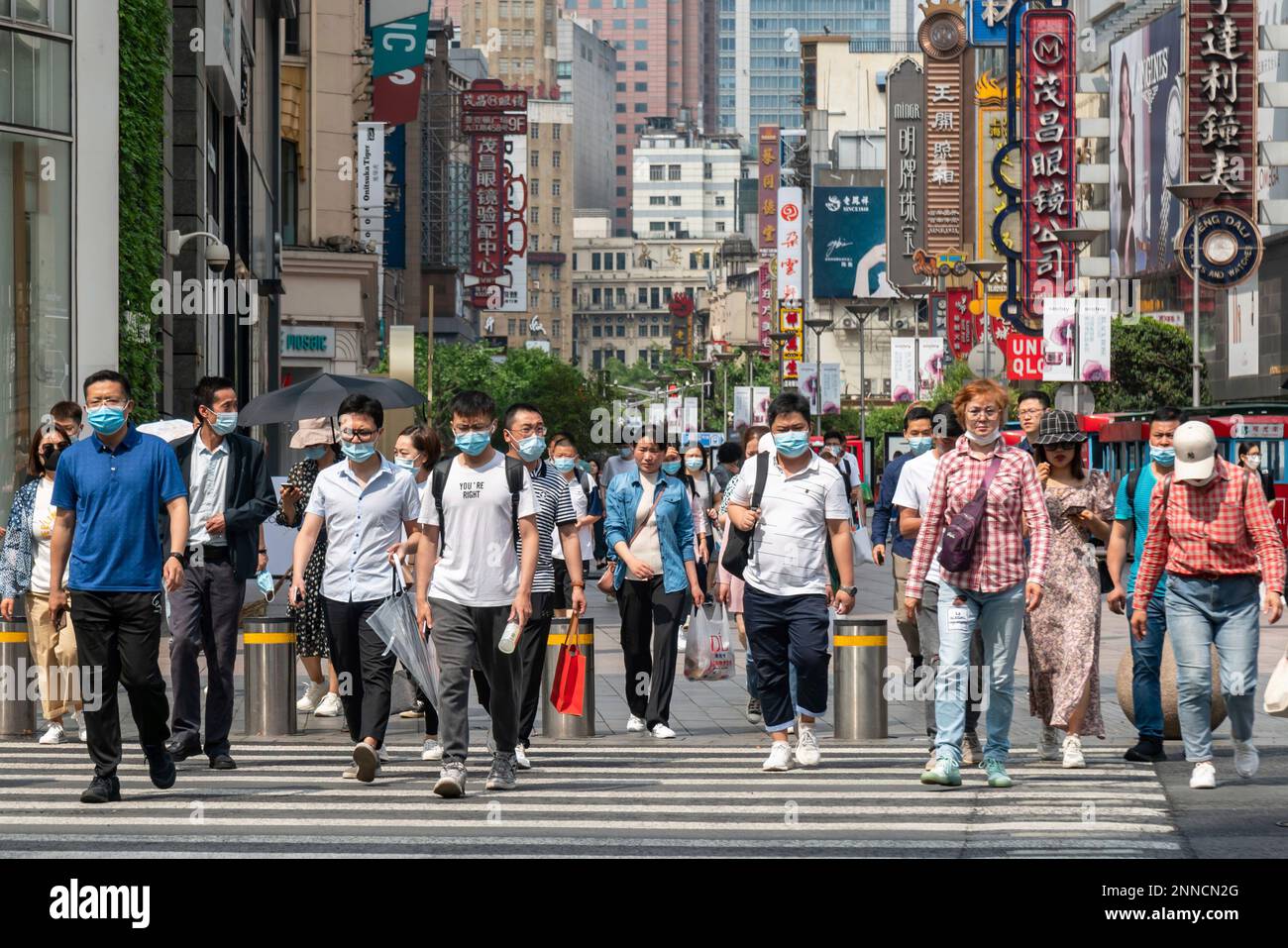 People cross a street in Shanghai, China Tuesday, May 11, 2021. China's ...
