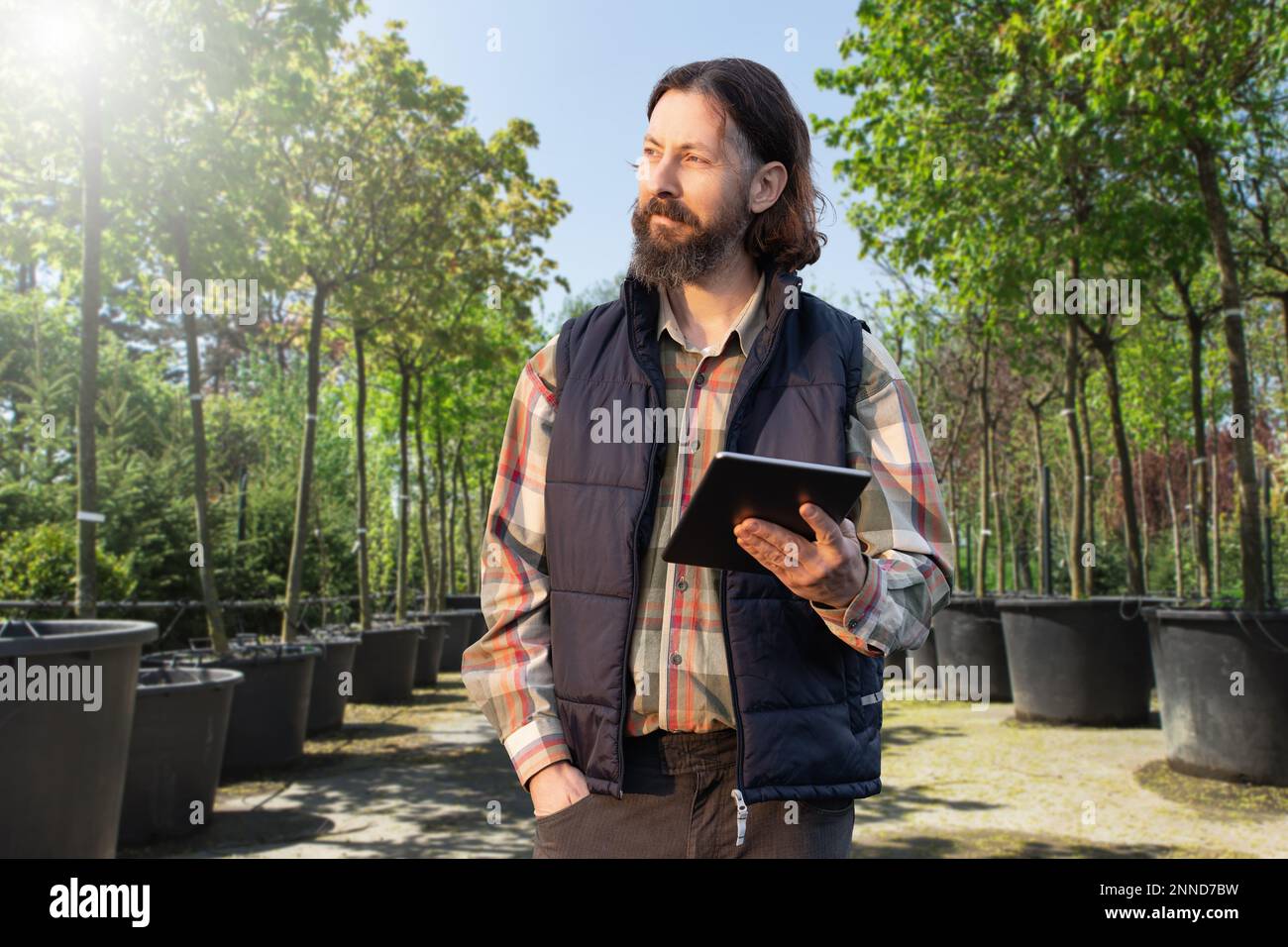 Man farmer holds a tablet in his hands. Growing plants Stock Photo - Alamy