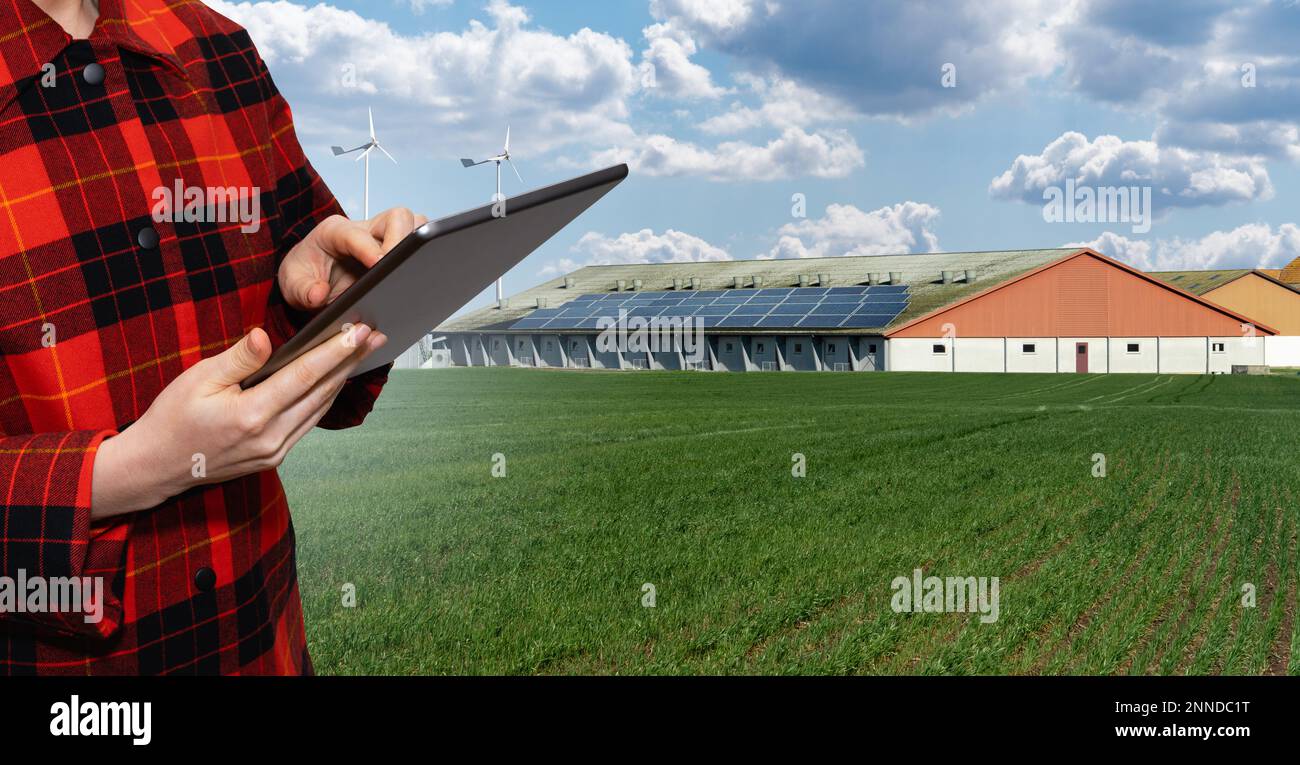 Farmer with tablet computer on a background of modern dairy farm using ...