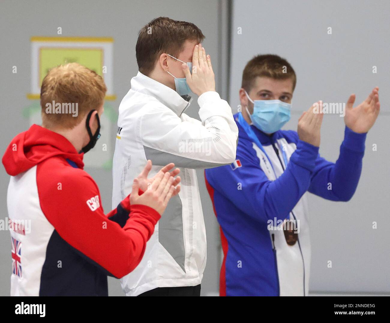Martin Wolfram (C) of Germany, gold, covers his face during the men's 3 ...