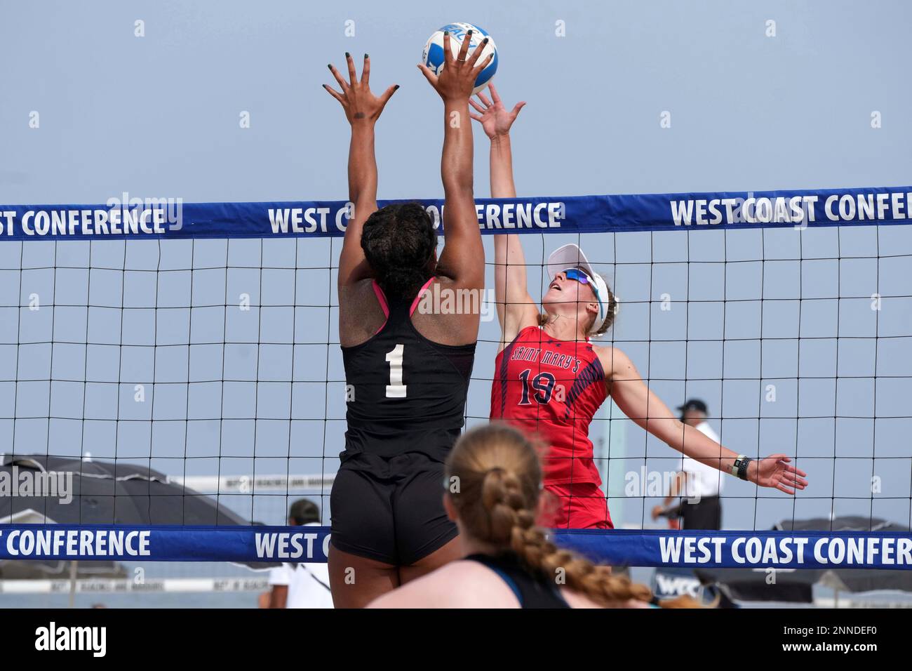 Chandler Cowell of Saint Mary's hits the ball over Alexa Edwards of ...