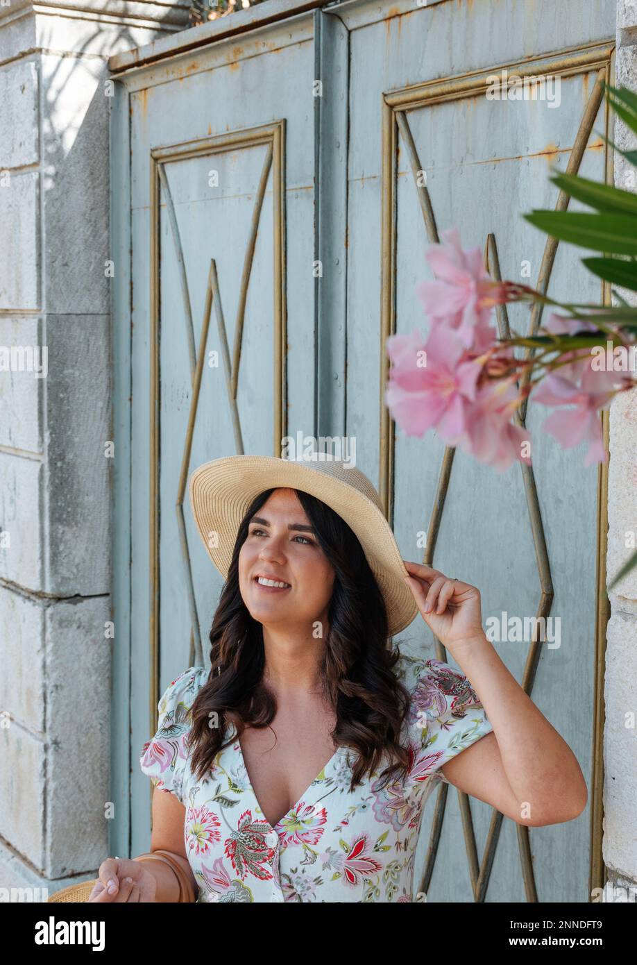 Portrait of beautiful girl wearing floral pattern dress and hat, posing ...