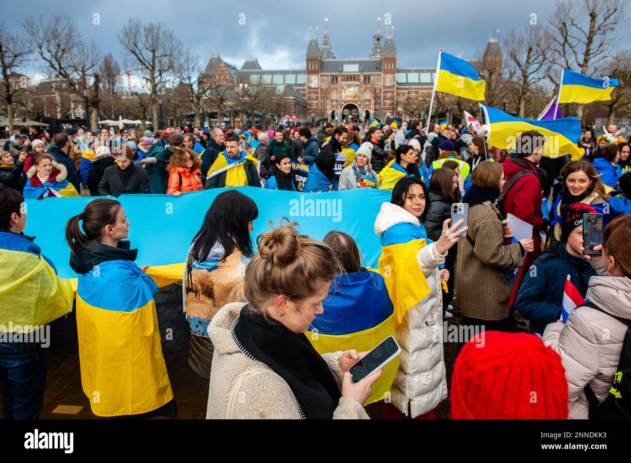 Ukrainian people are seen waiting to start marching holding a big ...