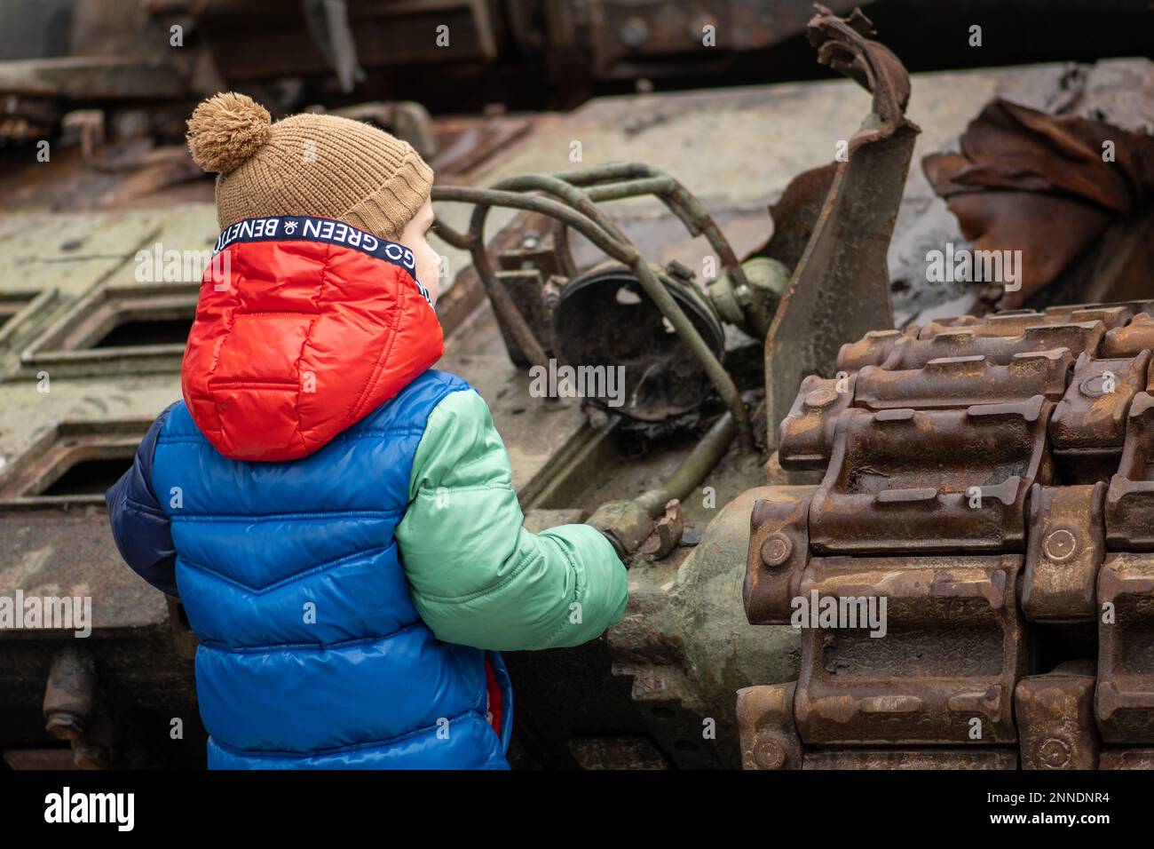 Child photographed near a burnt and melted rusty wreckage of a Soviet ...