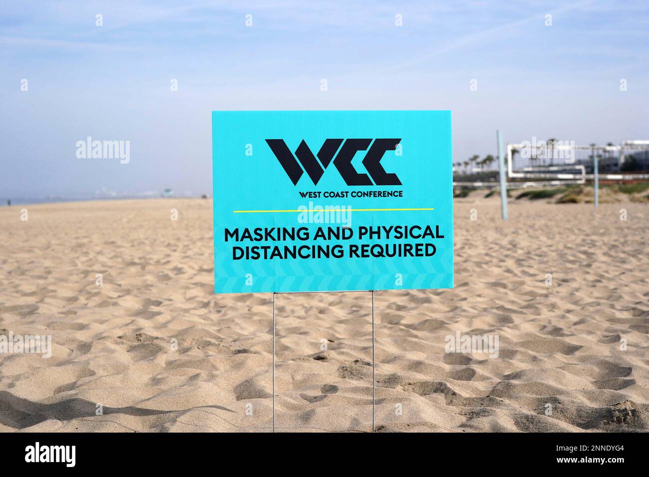 A masking and physical distancing sign at the WCC Beach Volleyball ...