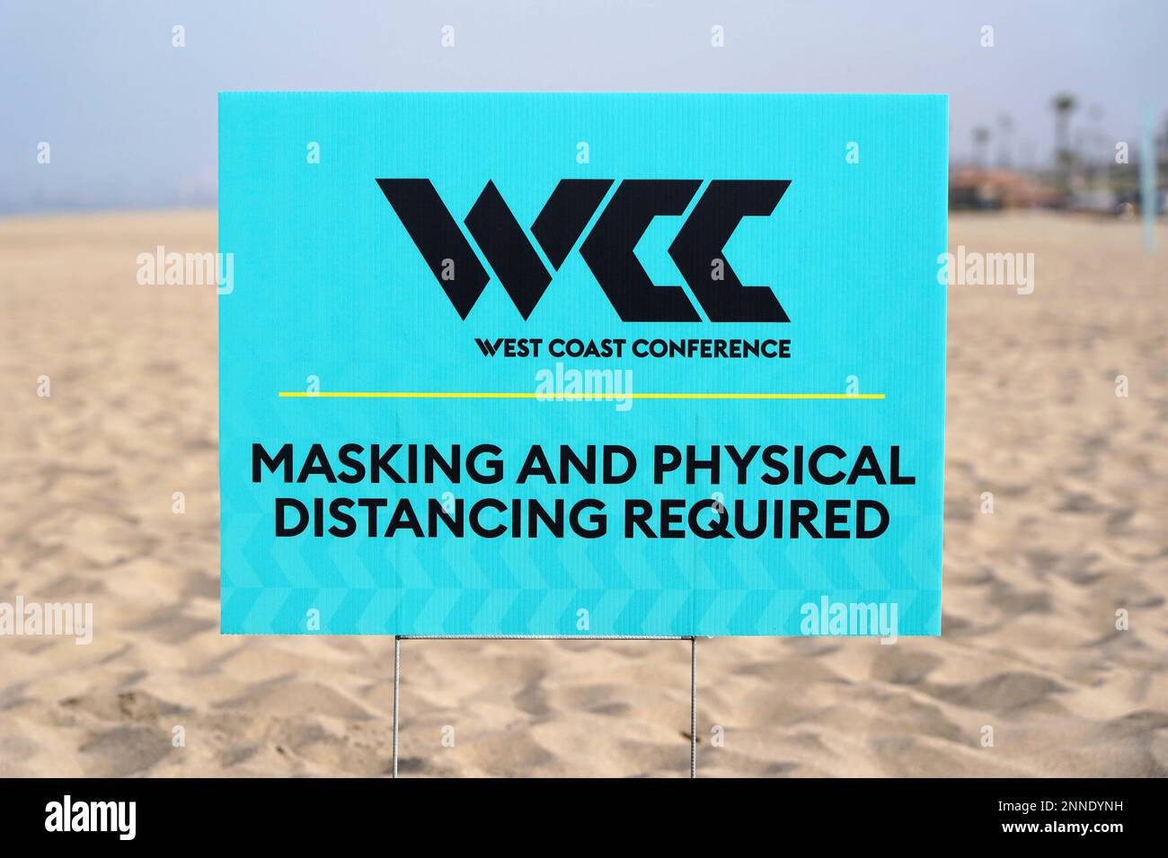 A masking and physical distancing sign at the WCC Beach Volleyball ...