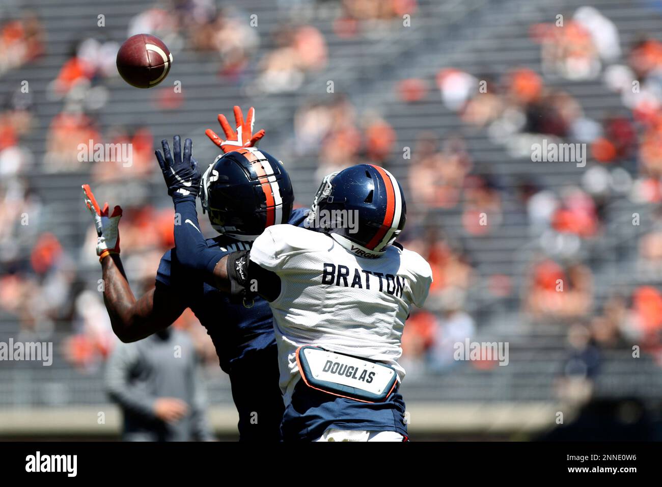 Virginia's Dontayvion Wicks reaches for the ball as Darrius Bratton defends from behind during ...