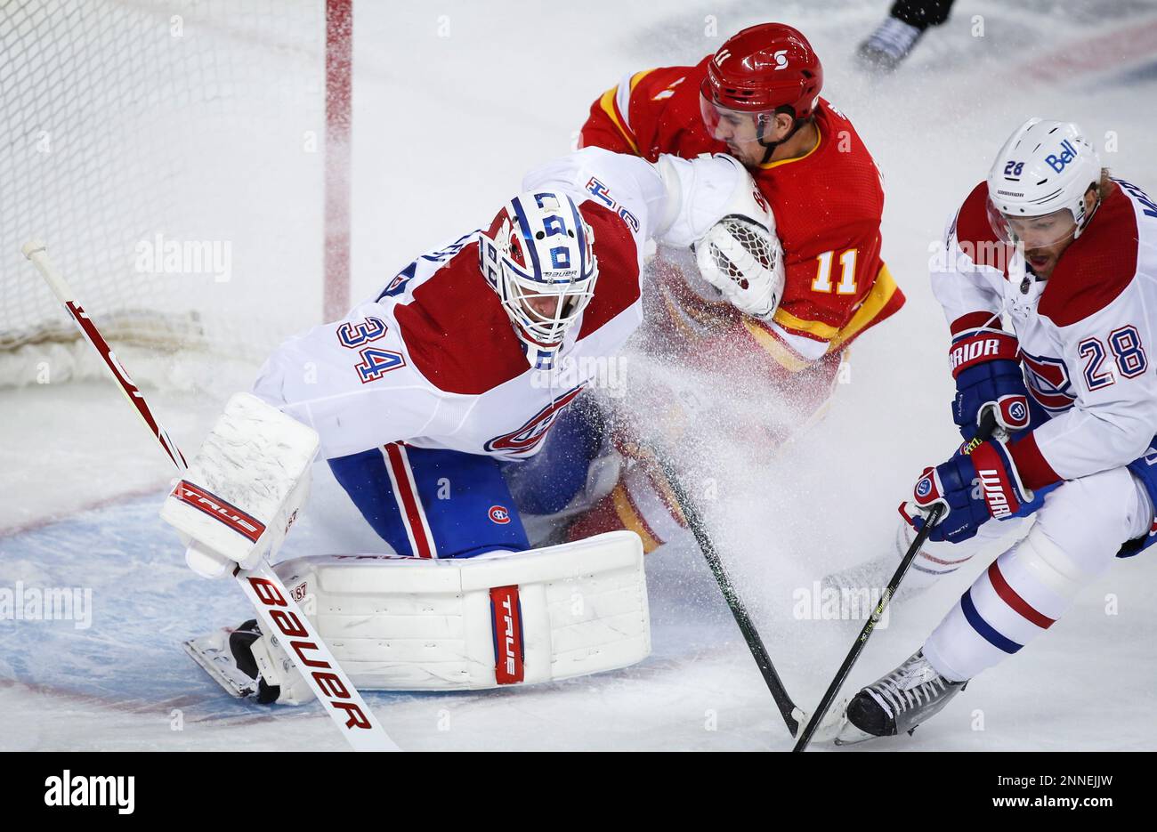 Montreal Canadiens goalie Jake Allen, left, fends off Calgary Flames ...
