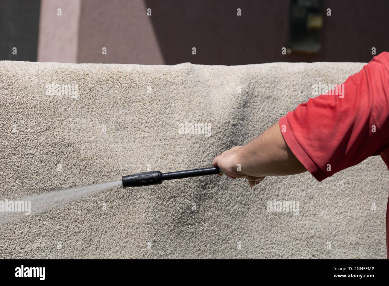 Washing carpets with high pressure washer. Cleaning the carpet with a gun for washing high ...