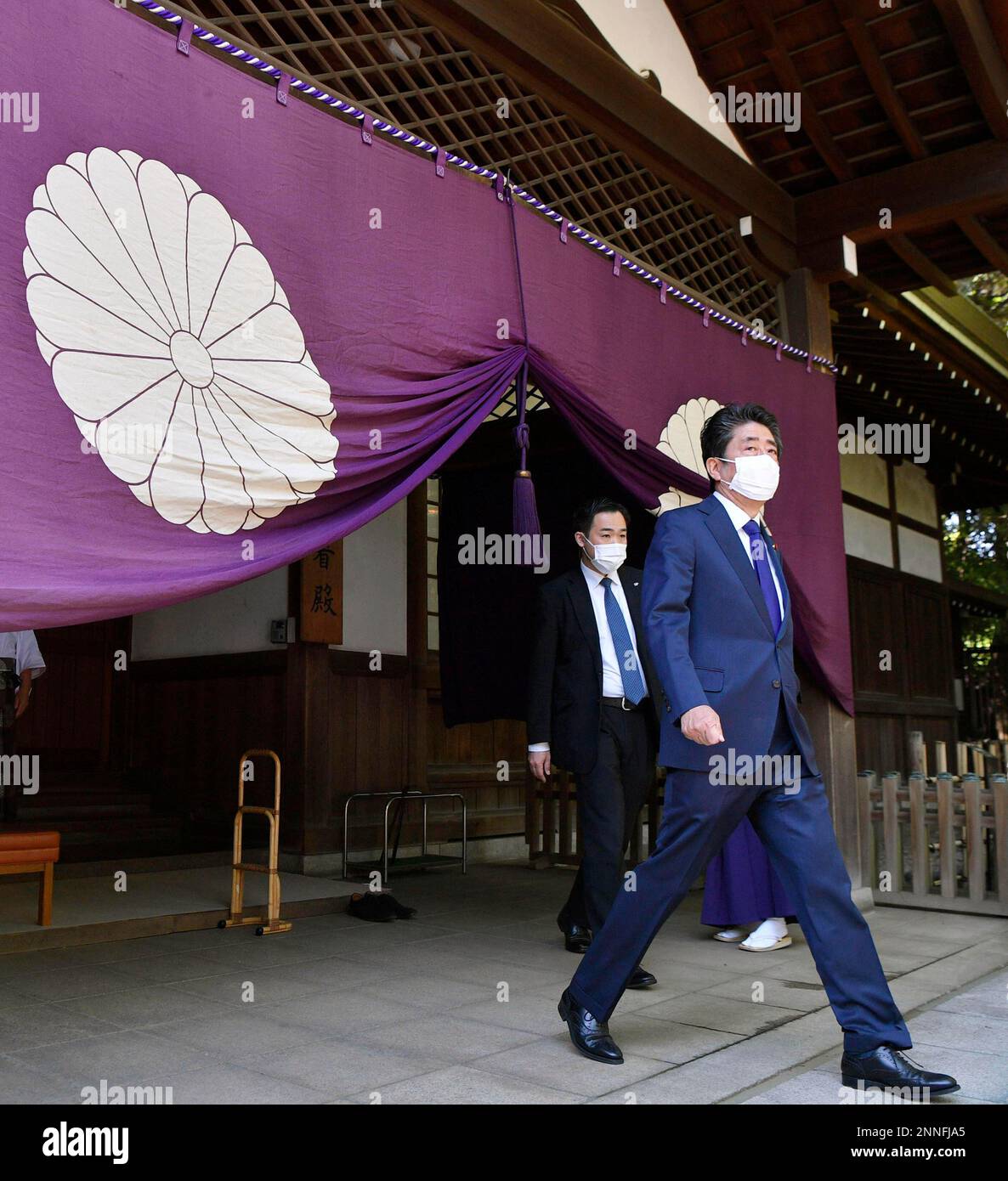 Former Japanese Prime Minister Shinzo Abe, right, leaves after praying ...