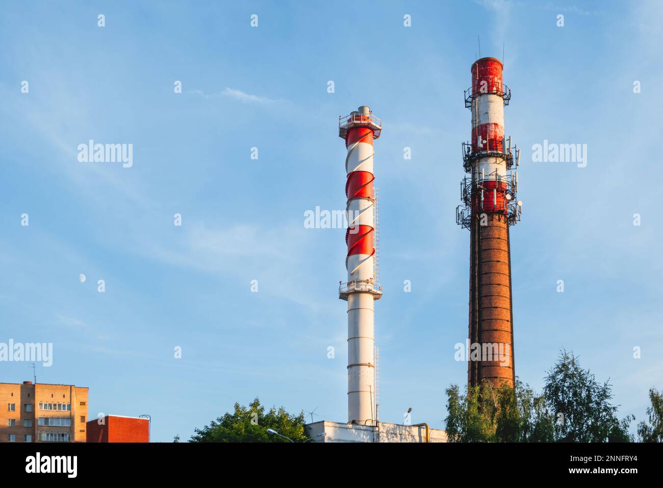 Boiler house chimney. Two towers against the clear blue sky. Industrial ...