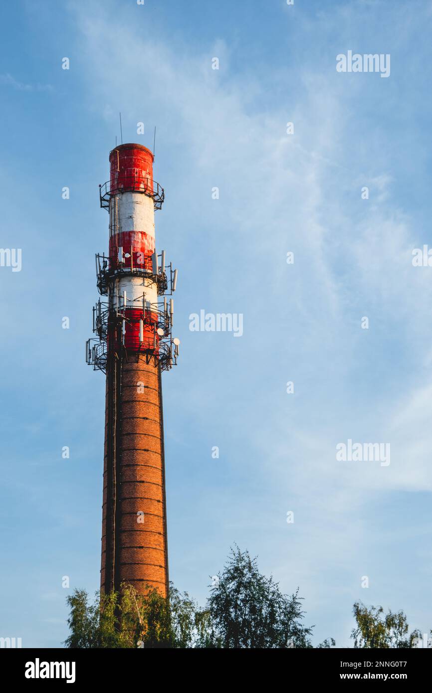 Boiler house chimney. Colorful tower against the clear blue sky ...