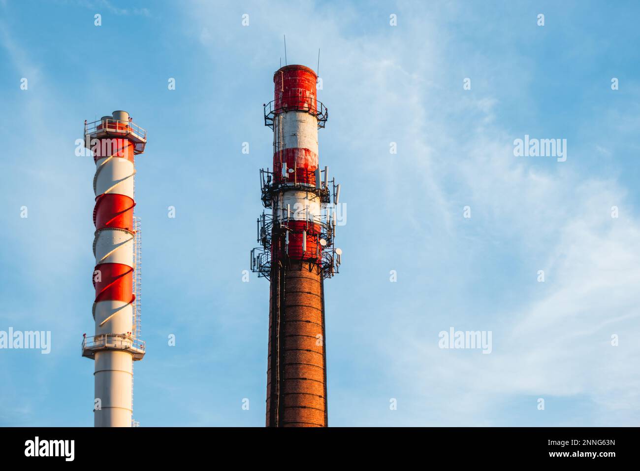 Boiler house chimney. Two towers against the clear blue sky. Industrial ...