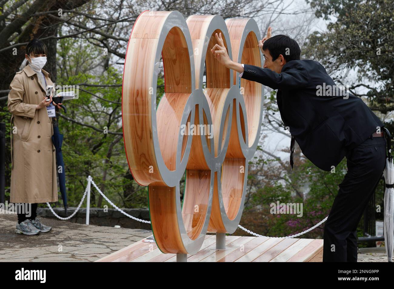 A man poses with a display of Olympic Symbol after unveiling ceremony ...