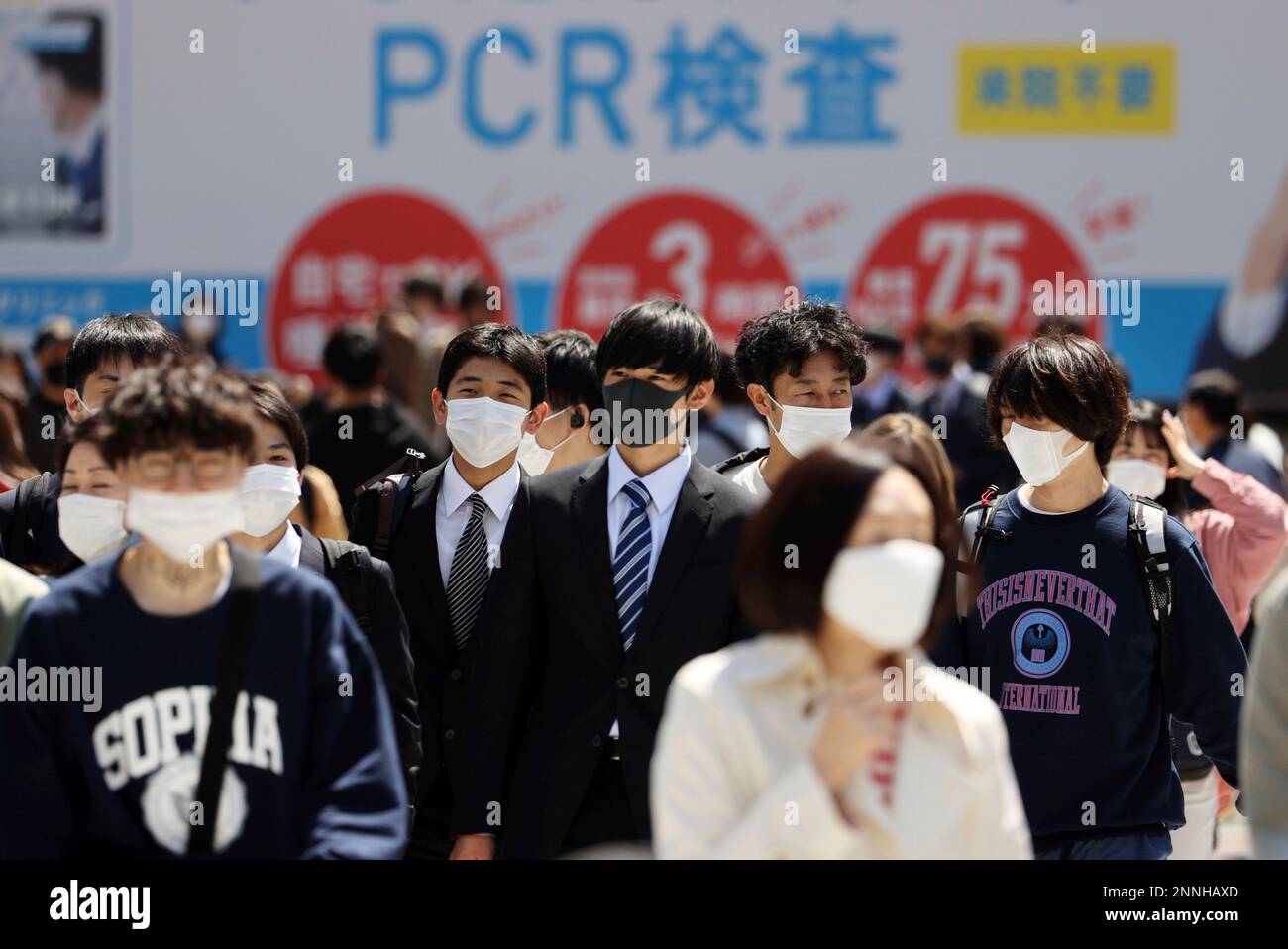 People wearing masks cross the Shibuya Scramble intersection in Tokyo ...