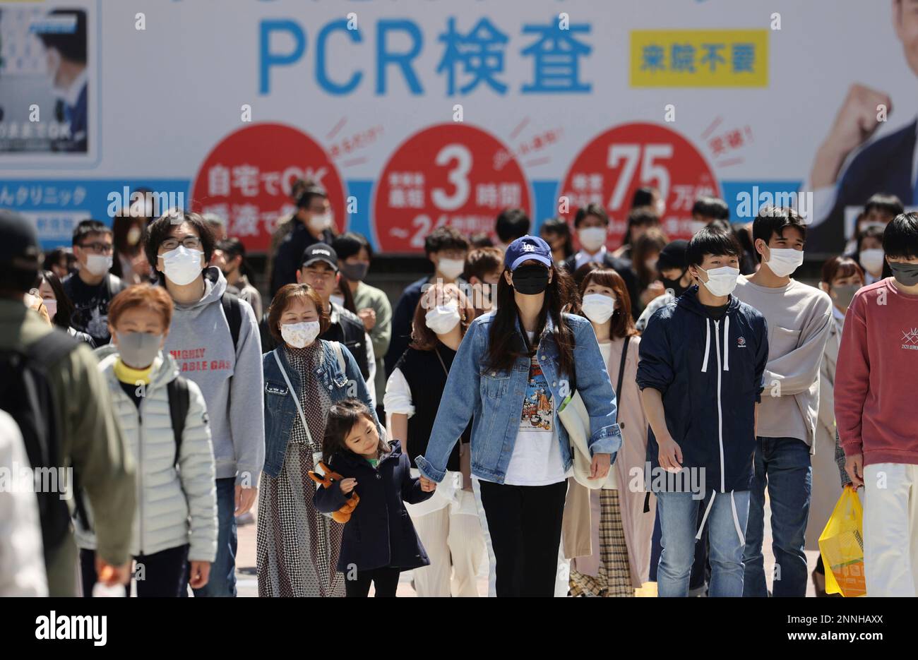 People wearing masks cross the Shibuya Scramble intersection in Tokyo ...