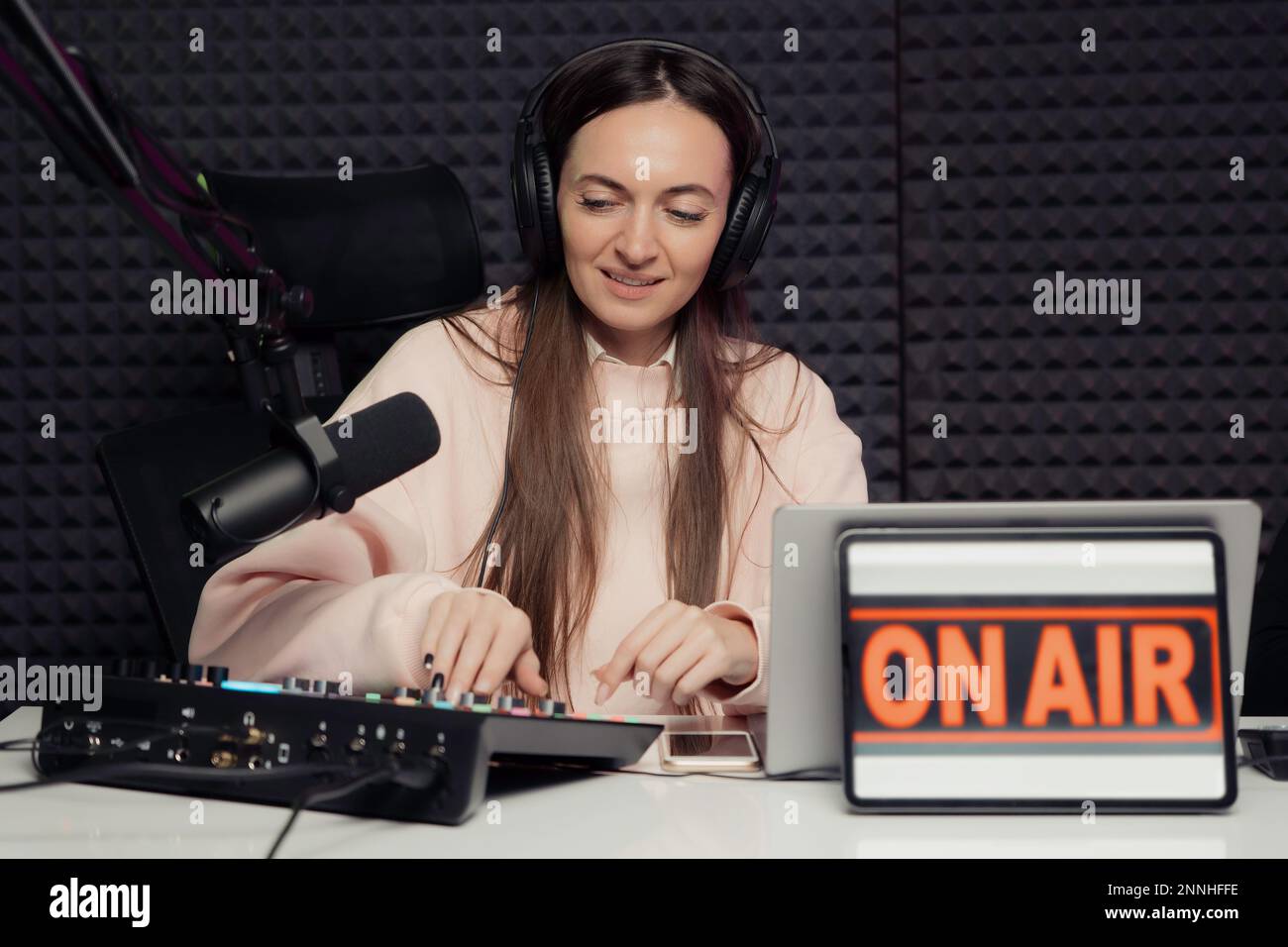 Woman using mixing console during broadcast Stock Photo - Alamy