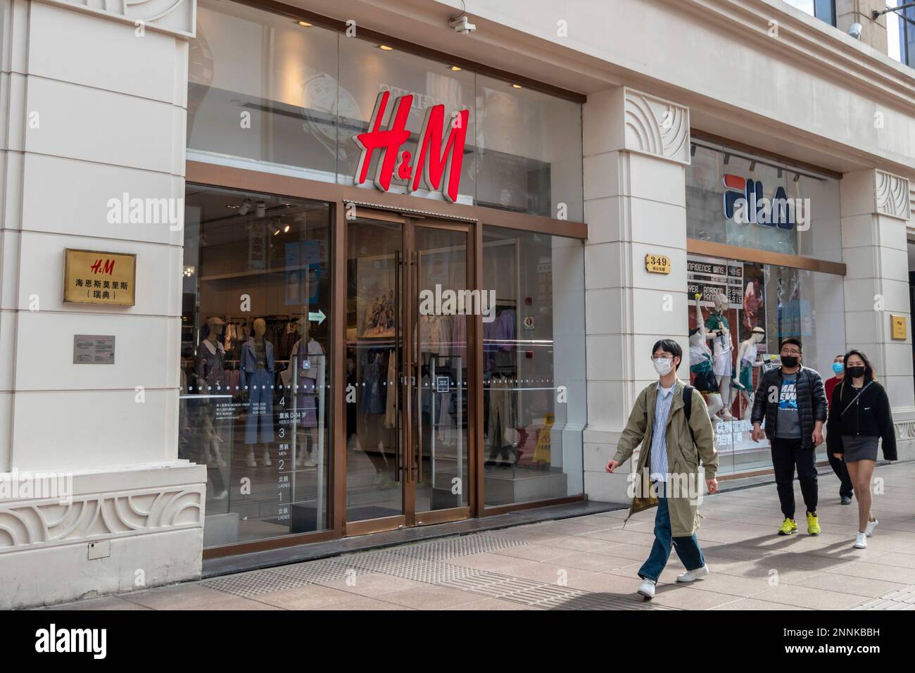 People walk by an H&M store in Shanghai, China Wednesday, March 24 ...