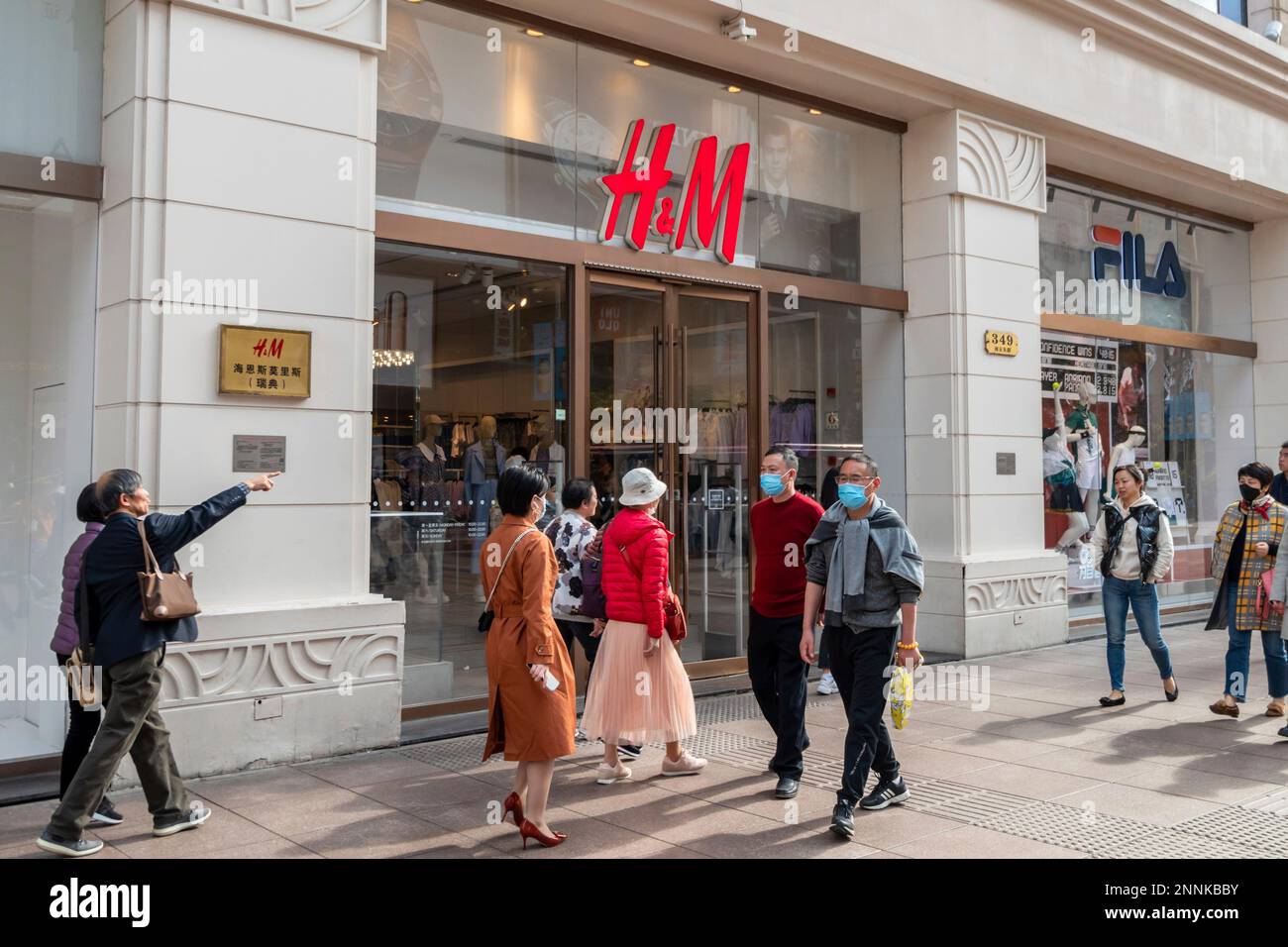 People walk by an H&M store in Shanghai, China Wednesday, March 24 ...