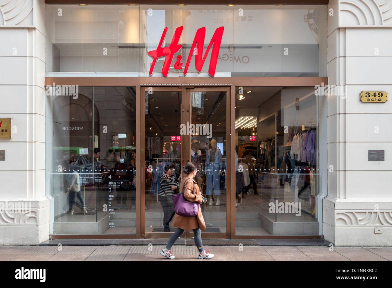 A woman walks by an H&M store in Shanghai, China Wednesday, March 24 ...