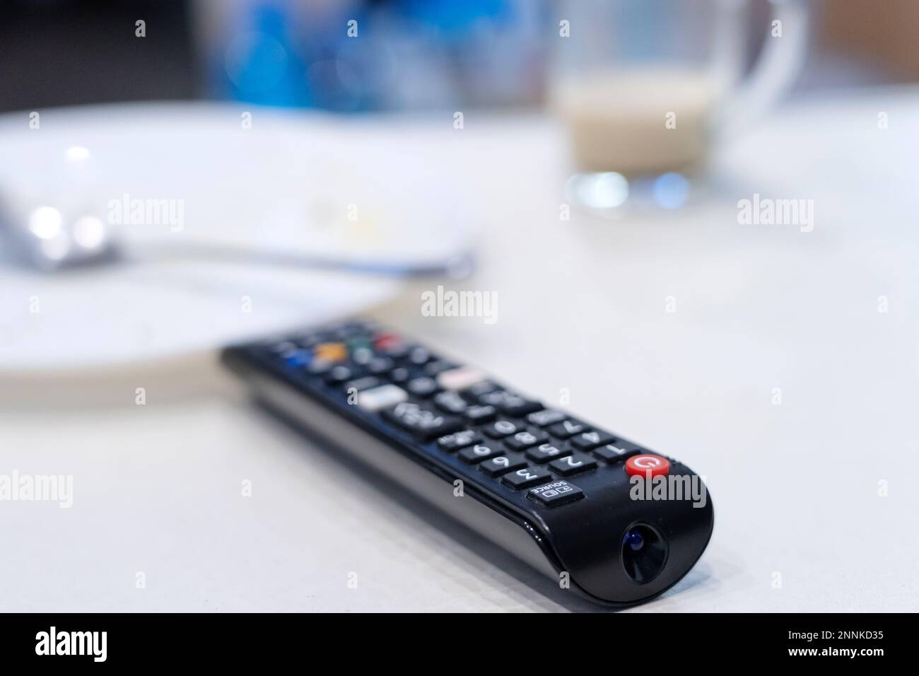 TV remote control on table, in kitchen next empty plate and cup, end ...