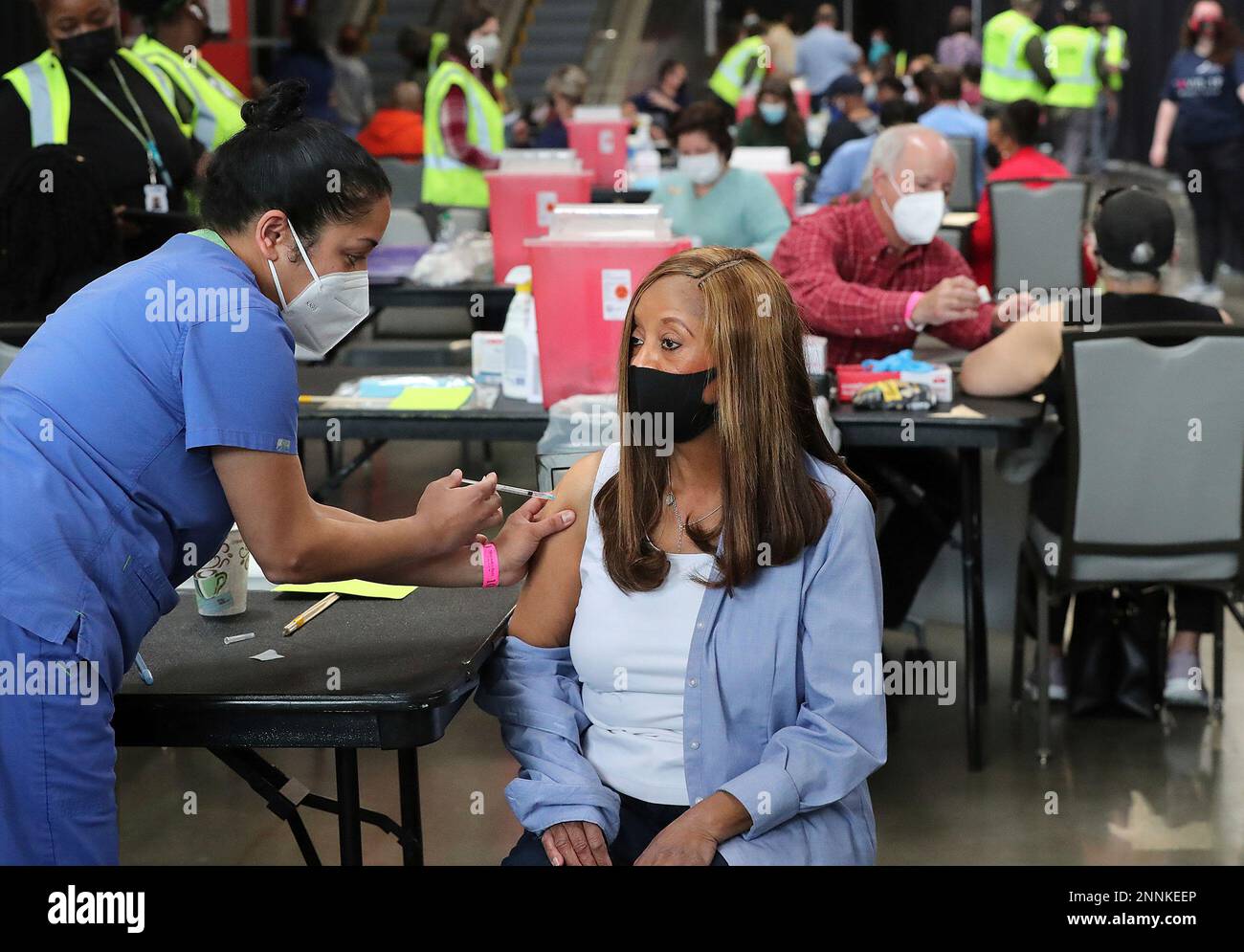 Anita Shetty (from left) vaccinates Doris Lucas with a Pfizer vaccine ...