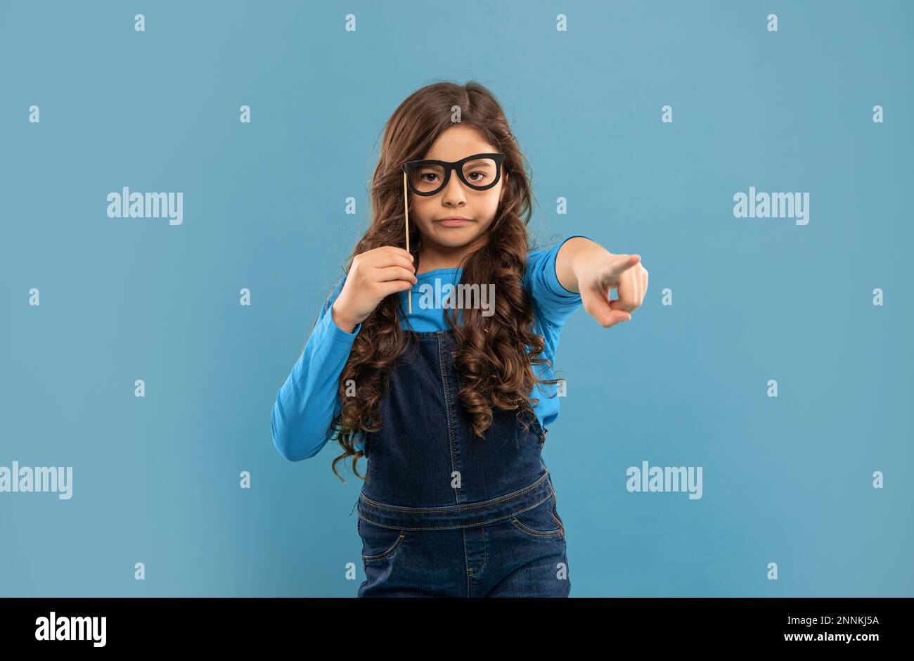 lets celebrate. kid with long curly hair on blue background. strict ...