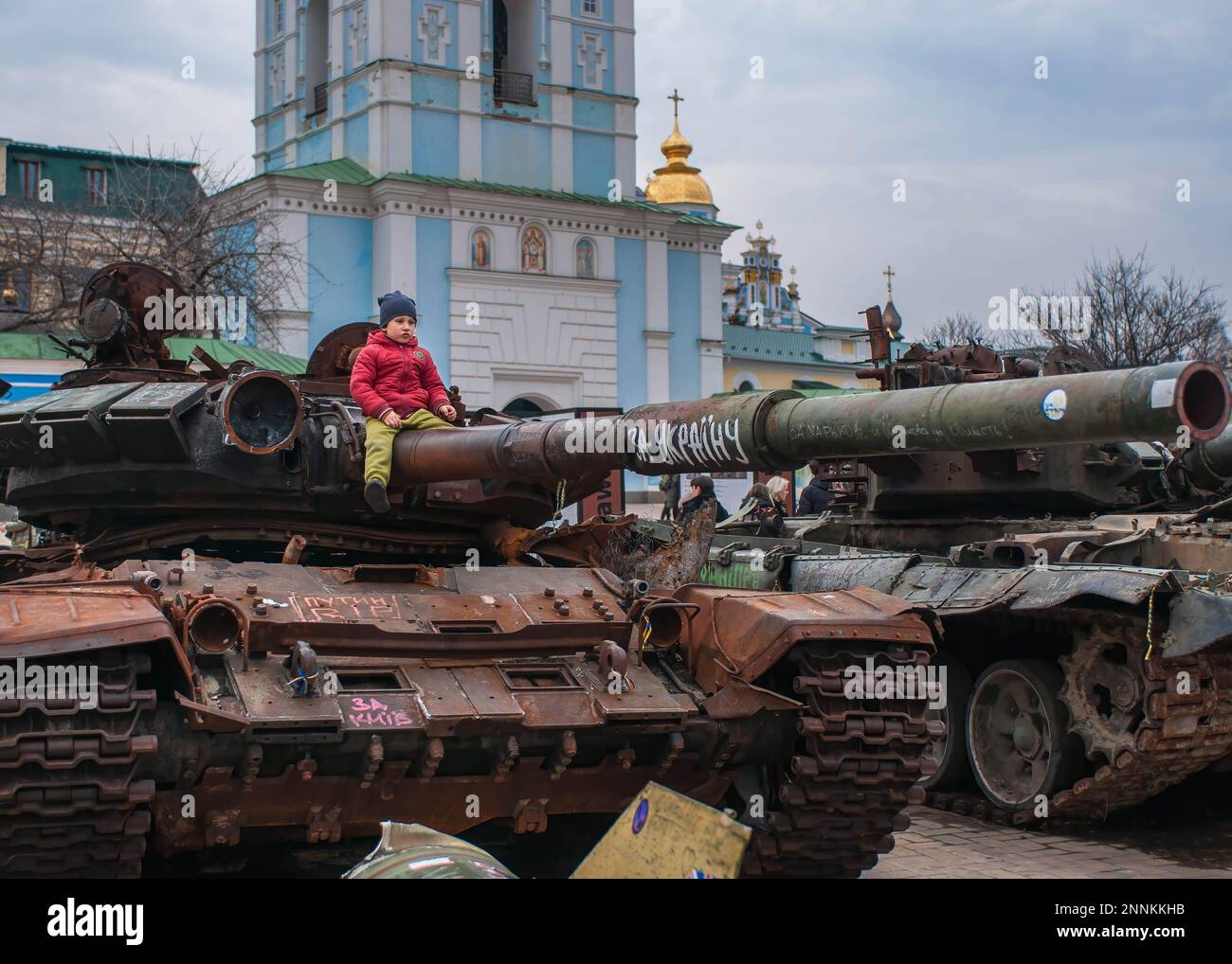 A child sits on the cannon of a tank destroyed by Ukrainian armed ...