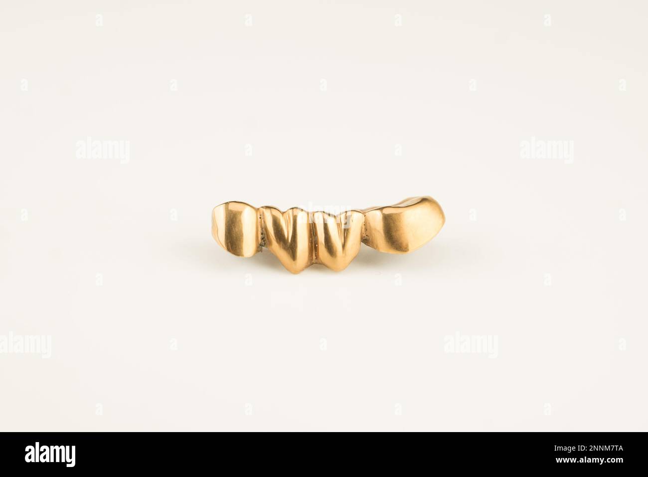 dental metal gold bridge isolated on white background Stock Photo - Alamy