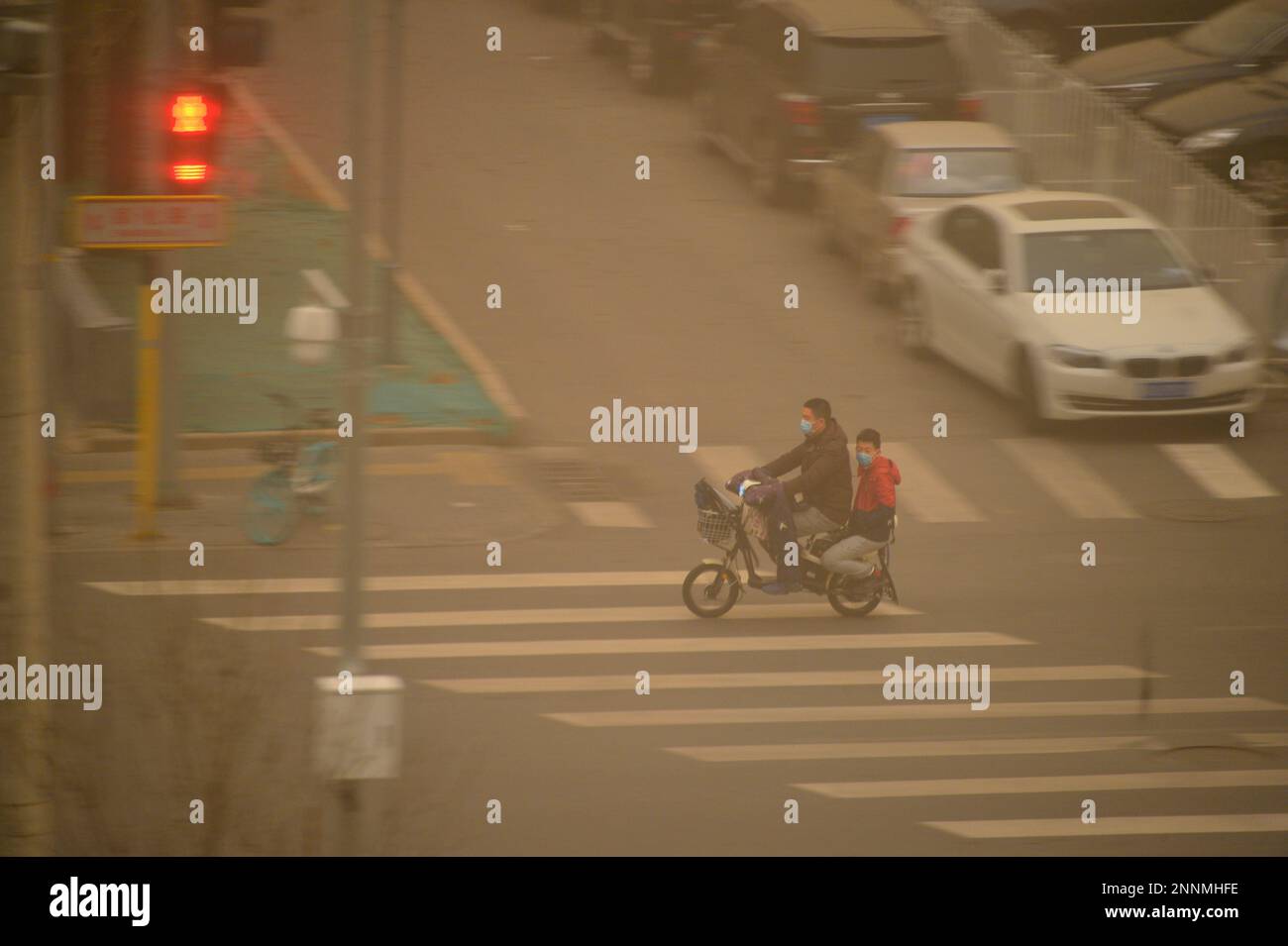 A father takes his son to the school in the sand storm in Beijing ...