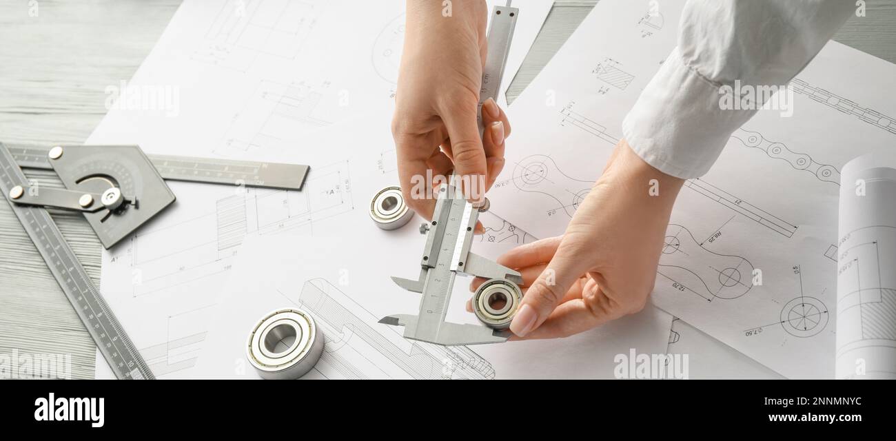 Working female engineer at table with drawings Stock Photo - Alamy