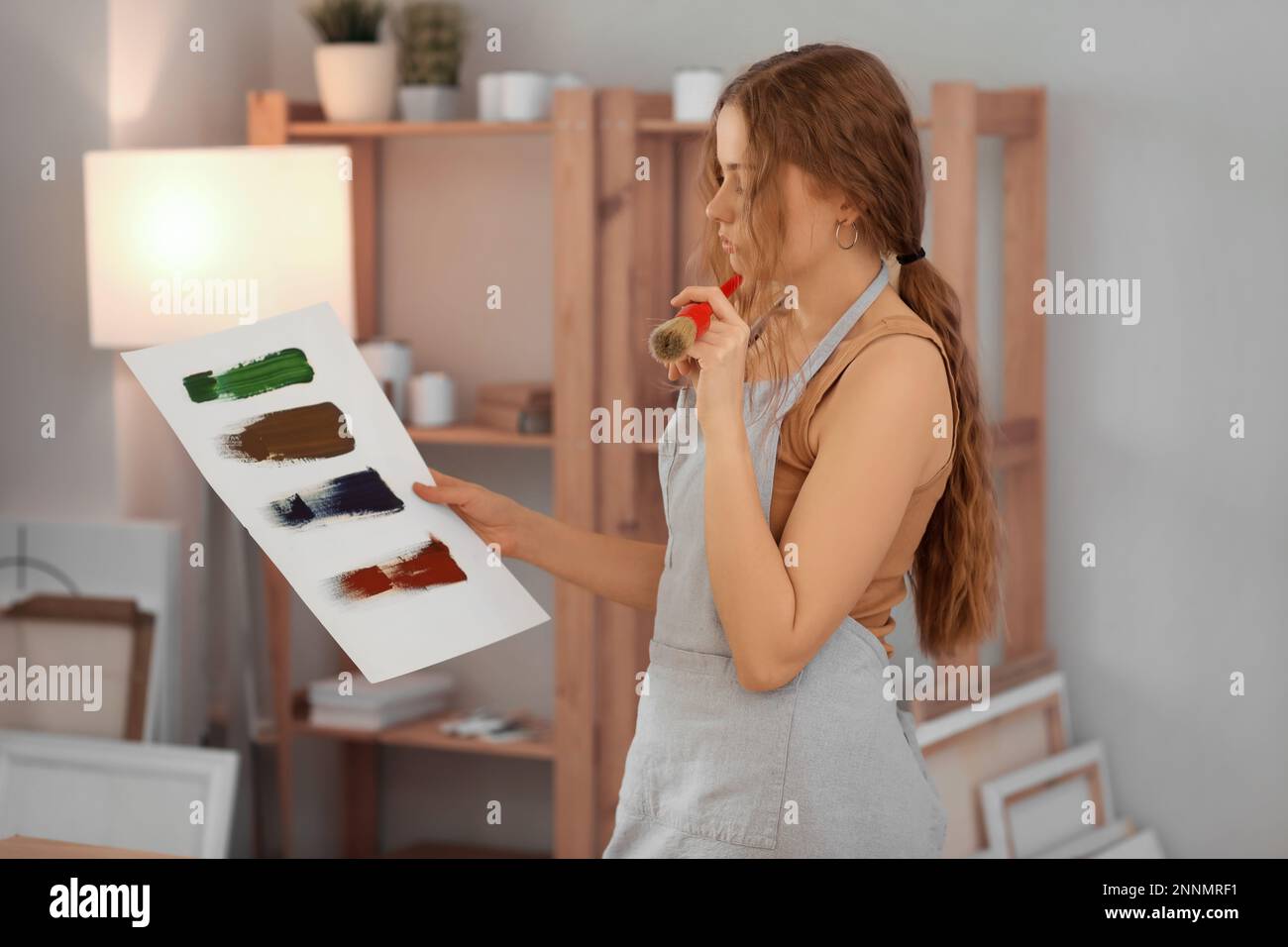Female artist with paint color palette and brush in workshop Stock ...
