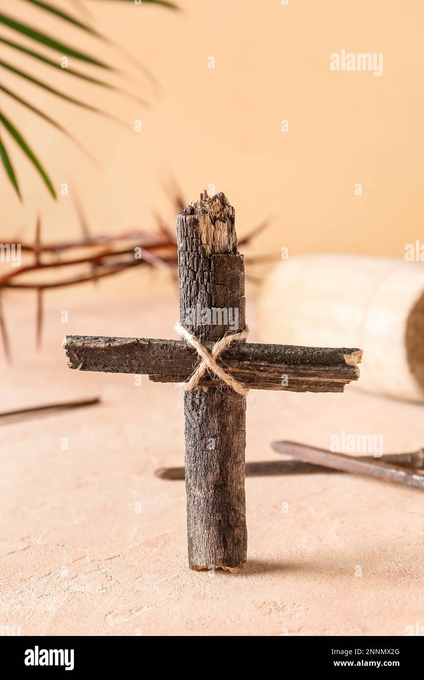 Wooden cross with nails on beige background, closeup. Good Friday ...